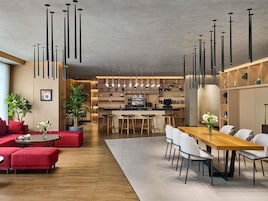 Um interior moderno com área de refeições, cozinha e assentos.