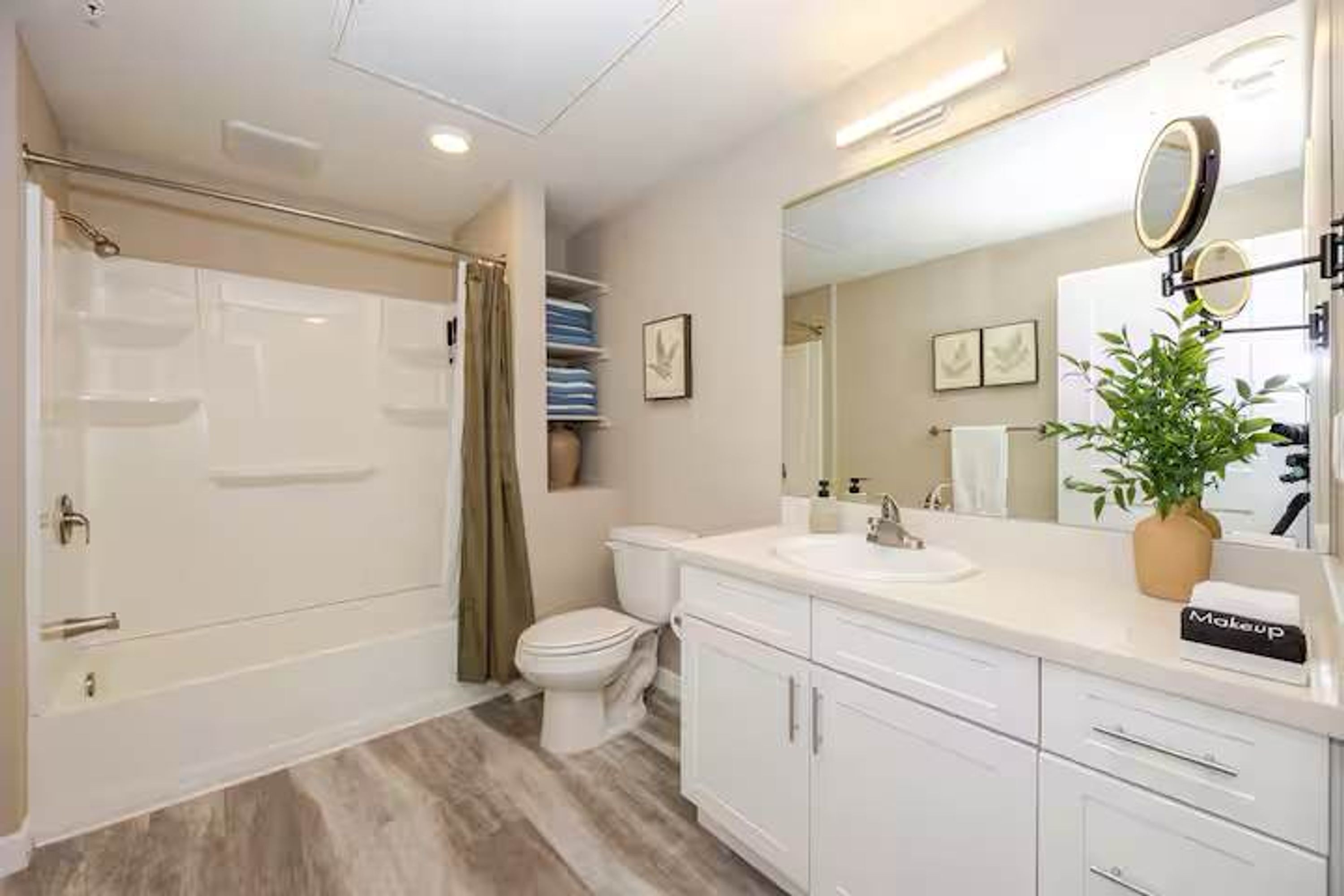 Uma casa de banho moderna com banheira, sanita e lavatório com espelho e lavatório.