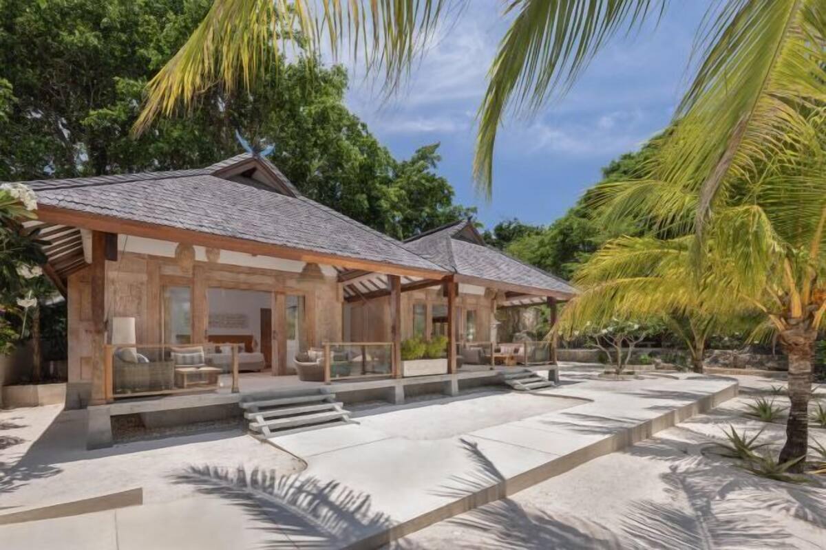 Um resort moderno com área de estar coberta ao ar livre, piscina e um jardim tropical.