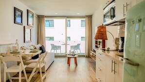 Um espaço compacto com área de jantar, cozinha compacta e varanda com vista.