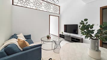 Apartamento Signature, várias camas | Sala de estar | Smart TV de 50 polegadas com canais digitais