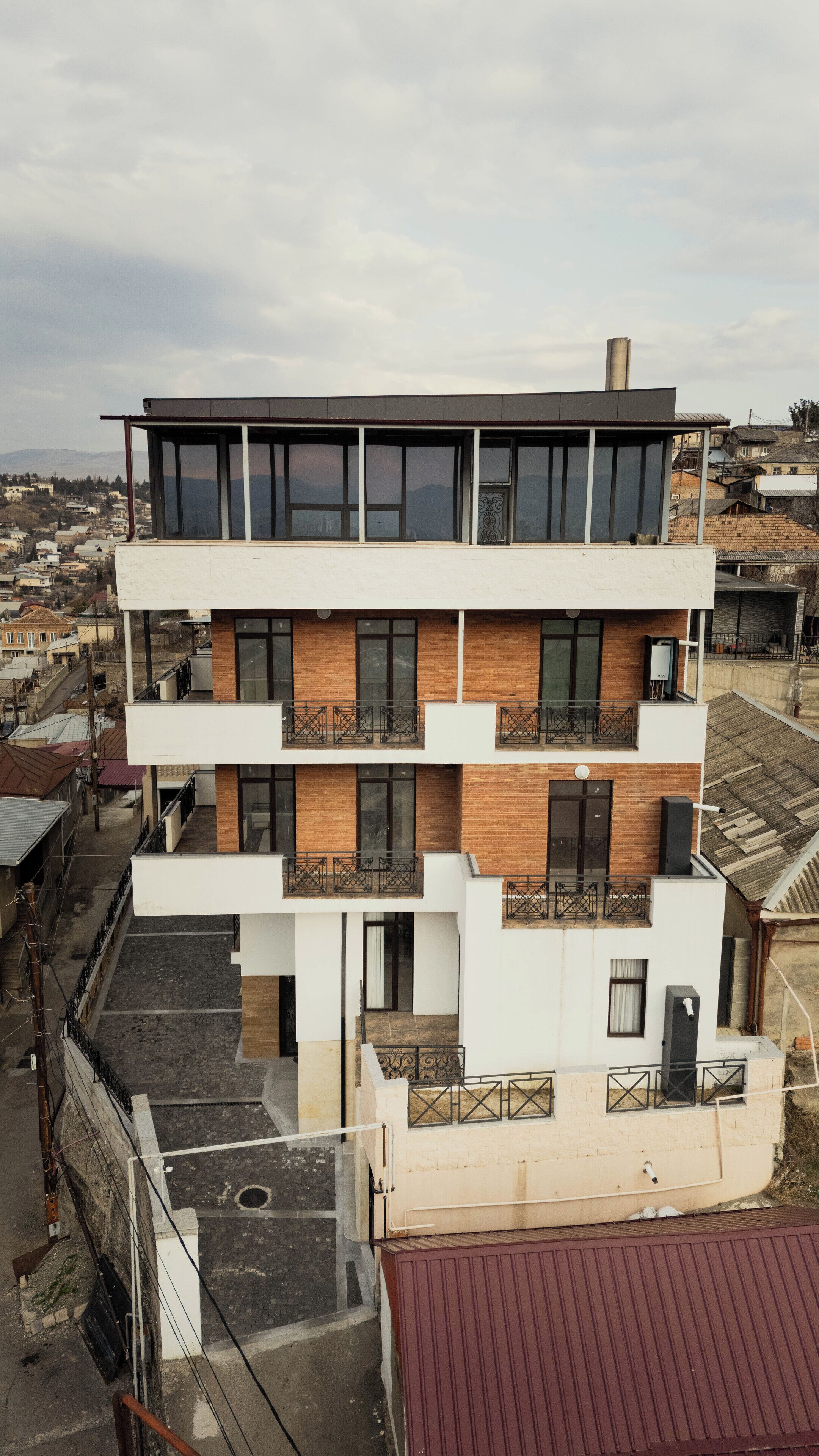 Um edifício de vários andares com varandas, janelas amplas e telhado plano.