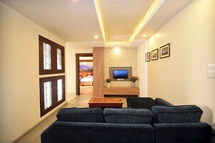 Apartamento família, 2 quartos, vista para a cidade | Área de estar | TV LED 32 polegadas com canais a cabo, livros, escritórios