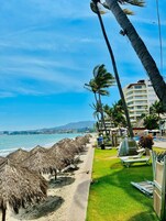 Na praia, espreguiçadeiras, guarda-sóis de praia, toalhas de praia 