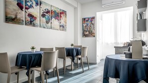 Uma sala de jantar com mesas, cadeiras e obras de arte nas paredes.