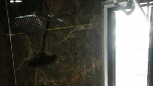 Casa de banho com chuveiro, sanita e janela.