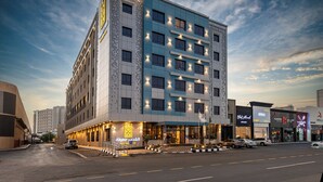 Hotel de vários andares com fachada moderna, exibindo um logotipo proeminente na lateral.