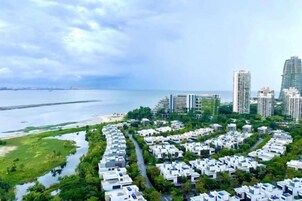 Zona residencial à beira-mar, com edifícios modernos, um porto de iates e uma praia.