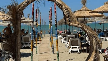 Praia particular, espreguiçadeiras, guarda-sóis, toalhas de praia