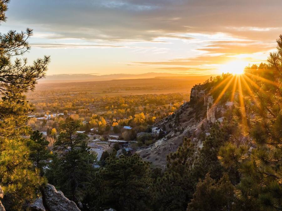 Paisagem montanhosa com vista para um vale e uma cidade lá embaixo.