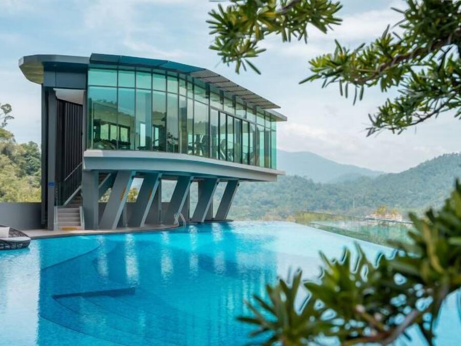 Um edifício moderno com fachada de vidro e vista para uma grande piscina.