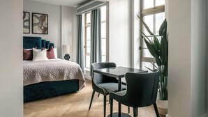 Quarto moderno com cama, escrivaninha e cadeiras.