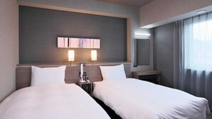 Quarto de hotel com duas camas, uma obra de arte grande presa à parede, luminárias de cabeceira, mesas de cabeceira, um espelho e uma janela com cortinas.