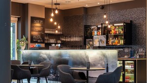 Uma área de bar moderna com balcão de mármore, diversas opções de assento e variedade de bebidas expostas.