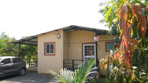 Um edifício térreo com fachada bege e porta vermelha, identificado com o número 3.
