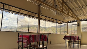 Um quarto espaçoso com amplas janelas proporcionando uma vista panorâmica de uma paisagem montanhosa.