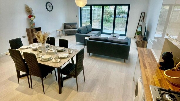Um interior moderno com área de jantar, sofá e cozinha.
