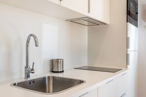 Um micro-ondas, uma máquina de lavar louça, uma cafeteira/bule 