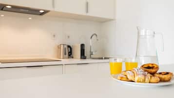 Uma máquina de lavar louça, uma cafeteira/bule, utensílios de cozinha