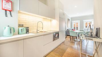 Um micro-ondas, uma cafeteira/bule, utensílios de cozinha