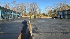 Um estacionamento com uma fileira de edifícios de motel de ambos os lados.