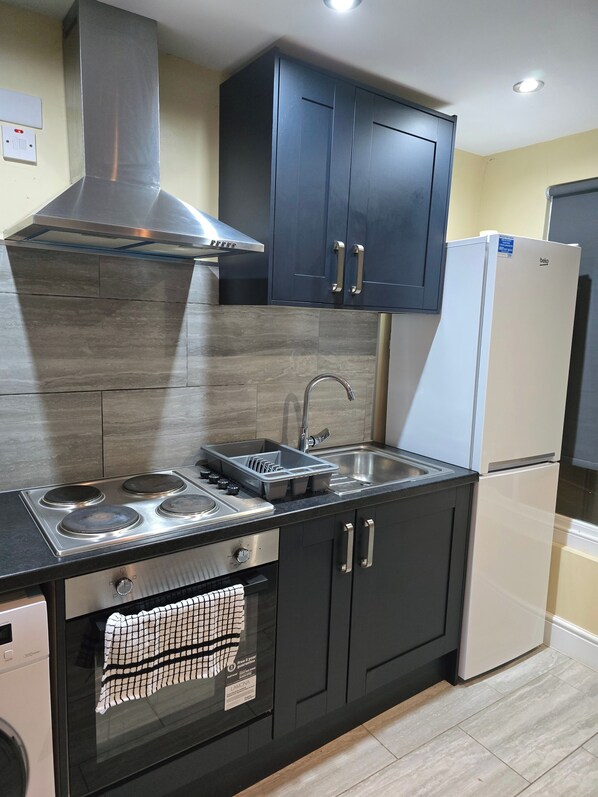 Um frigorífico, um micro-ondas, um forno, uma placa de cozinha