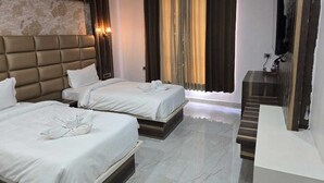 Quarto de hotel com duas camas, uma cabeceira grande, televisão de tela plana e uma escada.