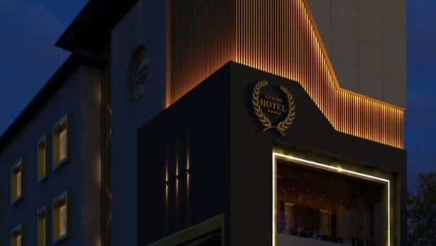Um hotel moderno com entrada imponente e placa indicando ser um estabelecimento de luxo.