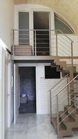 Um interior moderno com uma escada que leva a um quarto no mezanino.