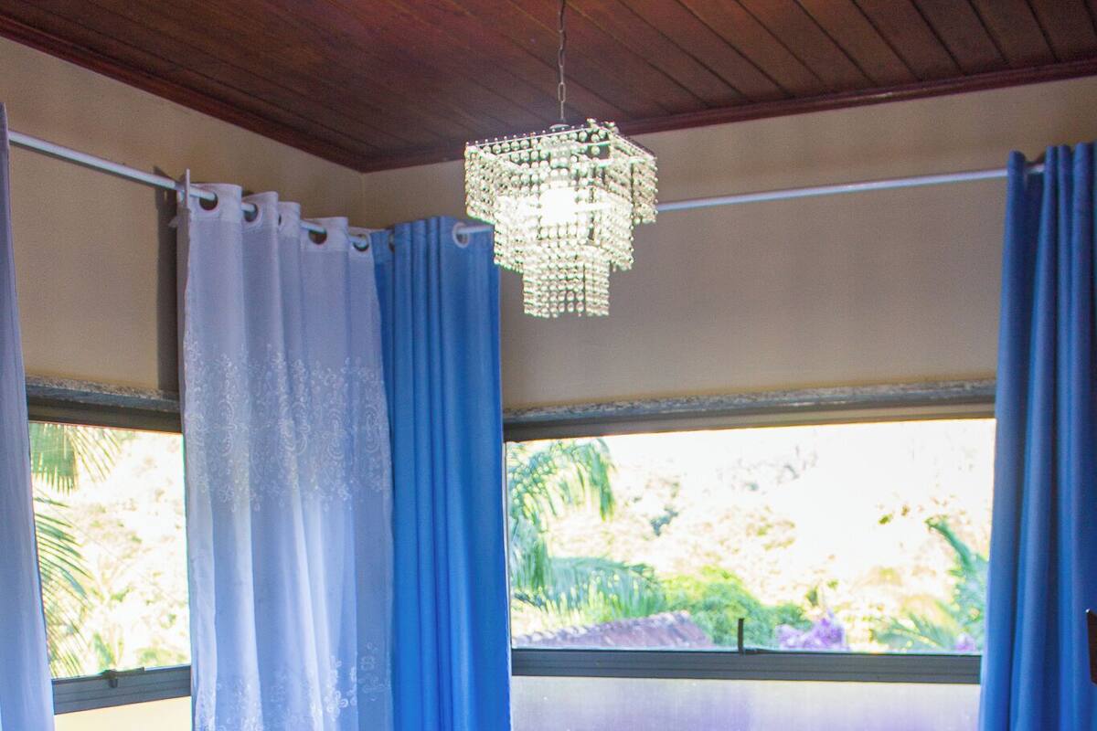 Um banheiro com banheira, um candelabro e vista para o exterior.