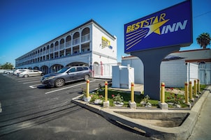 Um hotel BestStar Inn com estacionamento e um edifício com várias varandas.