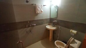 Um banheiro com pia, espelho, porta-toalhas e vaso sanitário.