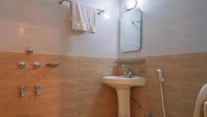 Um banheiro com pia, vaso sanitário e lixeira.