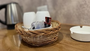 Uma cesta de vime com um saquinho de chá, embalagem e uma colher sobre uma mesa de madeira.