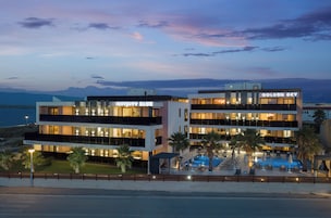 Um hotel moderno com vários andares, piscina e vista para as montanhas.