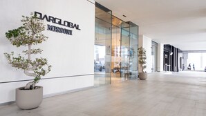 Um edifício moderno com fachada de vidro e uma placa com a inscrição 'DARGLOBAL MISSION'.
