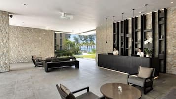 Um lobby moderno com parede de pedra, área de estar e balcão de recepção.