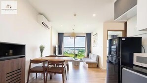 Um apartamento moderno com área de refeições, cozinha e uma grande janela com vista para a cidade.