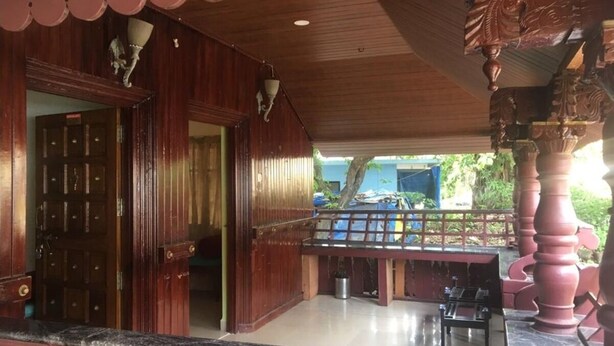 Varanda de madeira com um banco, uma mesa e vista para o exterior.