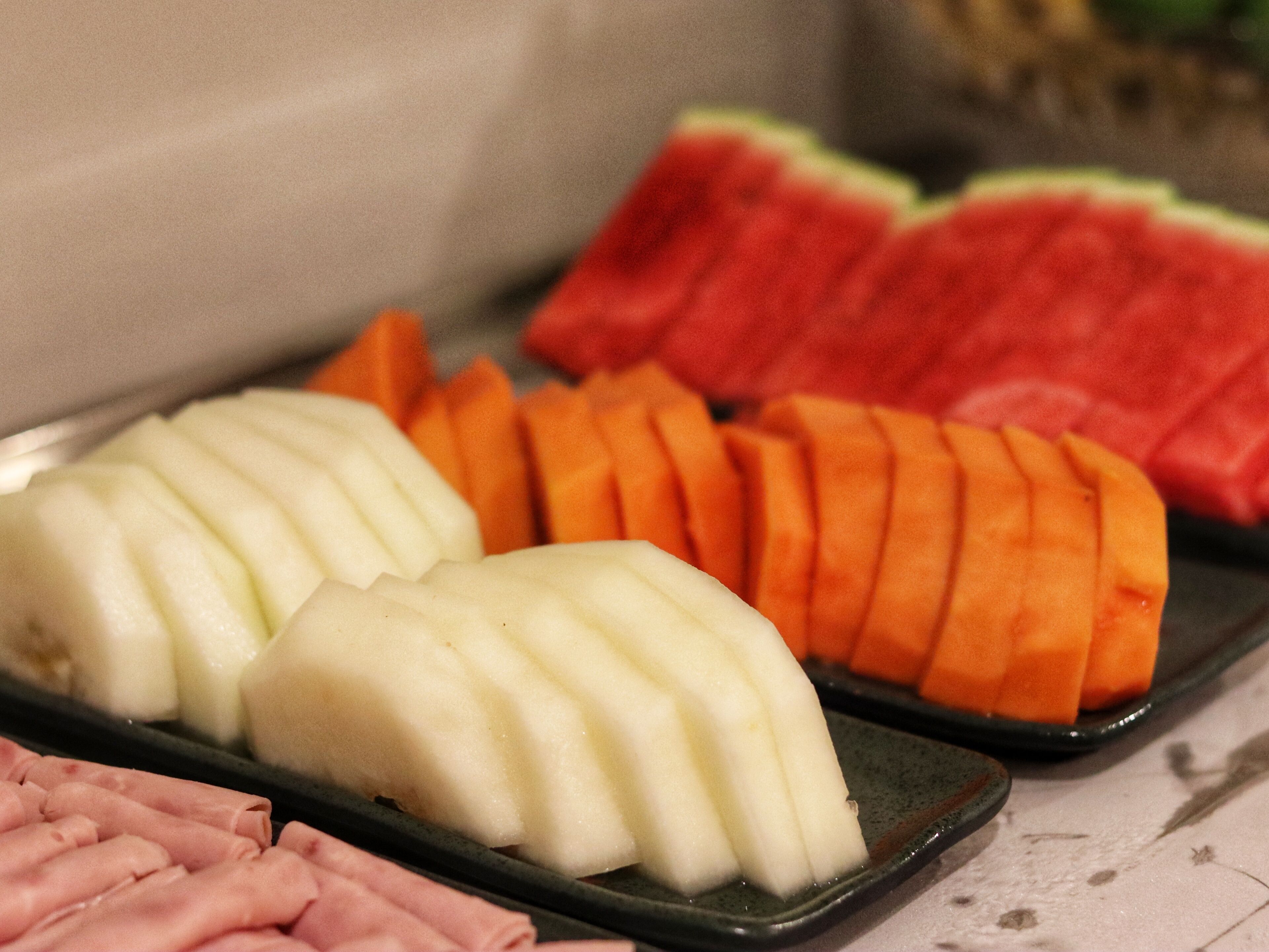Uma bandeja com melancia, melão e presunto fatiados.