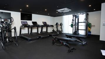 Uma academia com esteiras, elípticos e equipamentos de musculação.