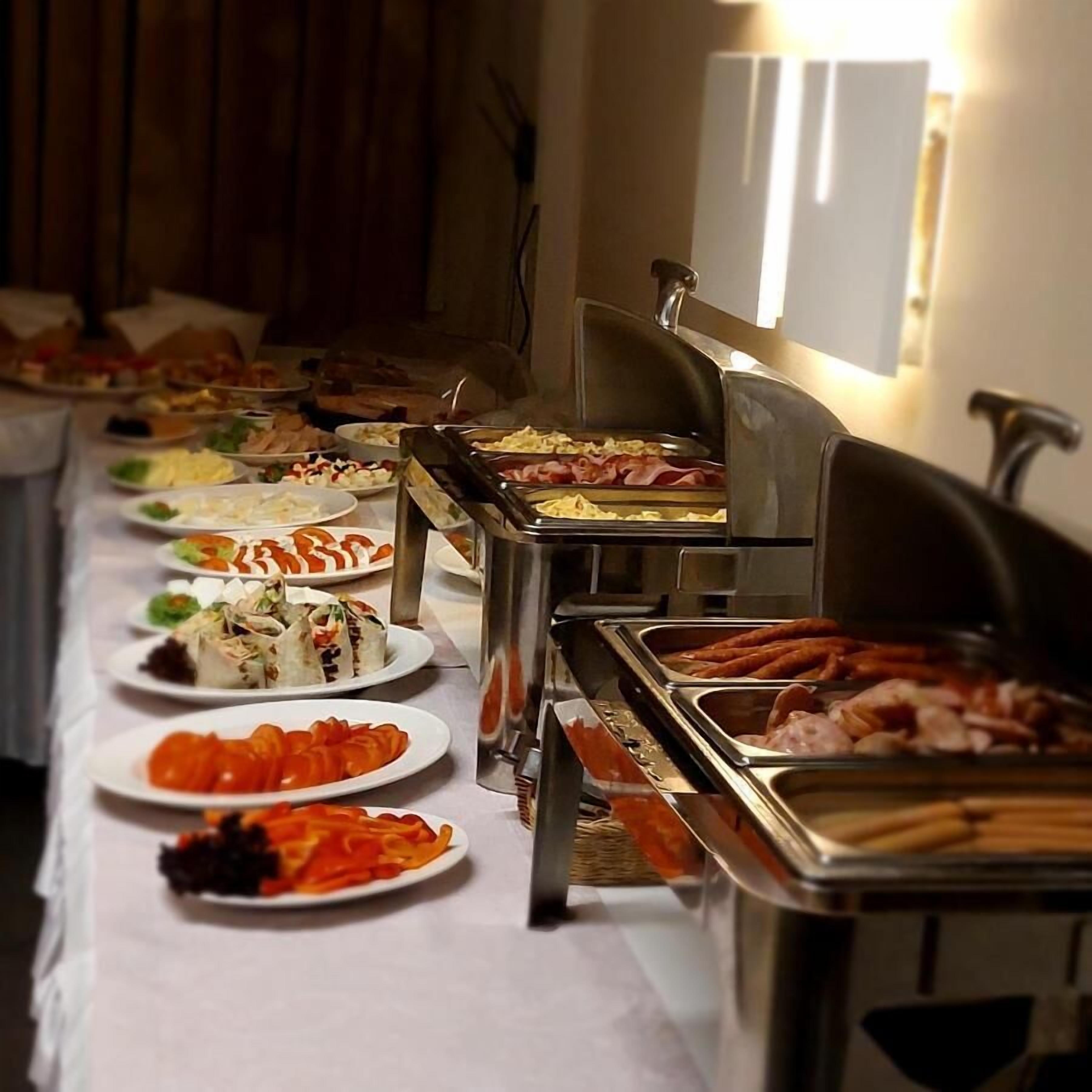 Uma mesa de buffet com diversos alimentos e um espaço para grelhados.
