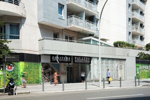 Um hotel moderno com varandas, uma parede verde e uma placa com o nome 'Zenitude Hotel Residences'.