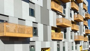 Um edifício moderno de vários andares com varandas e janelas amplas.