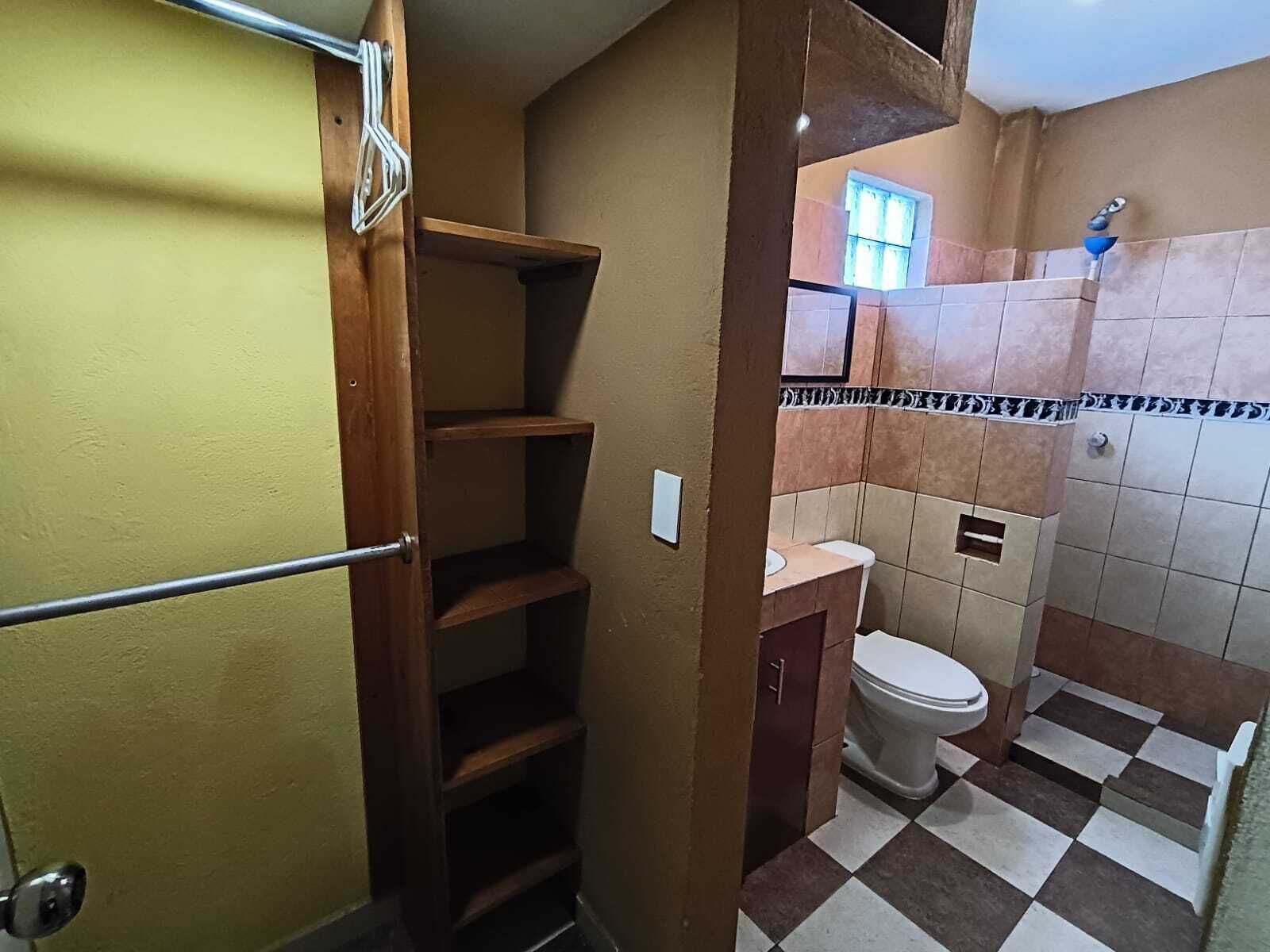 Casa de banho com sanita, lavatório e zona de duche.