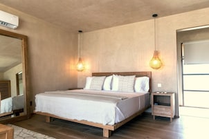 Um quarto com uma cama de madeira, duas luminárias de cabeceira, uma mesa de cabeceira e um espelho grande.