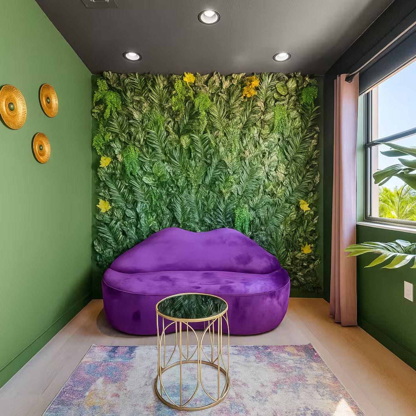 Quarto com parede verde, poltrona de pelúcia roxa, mesa redonda dourada e tapete estampado.