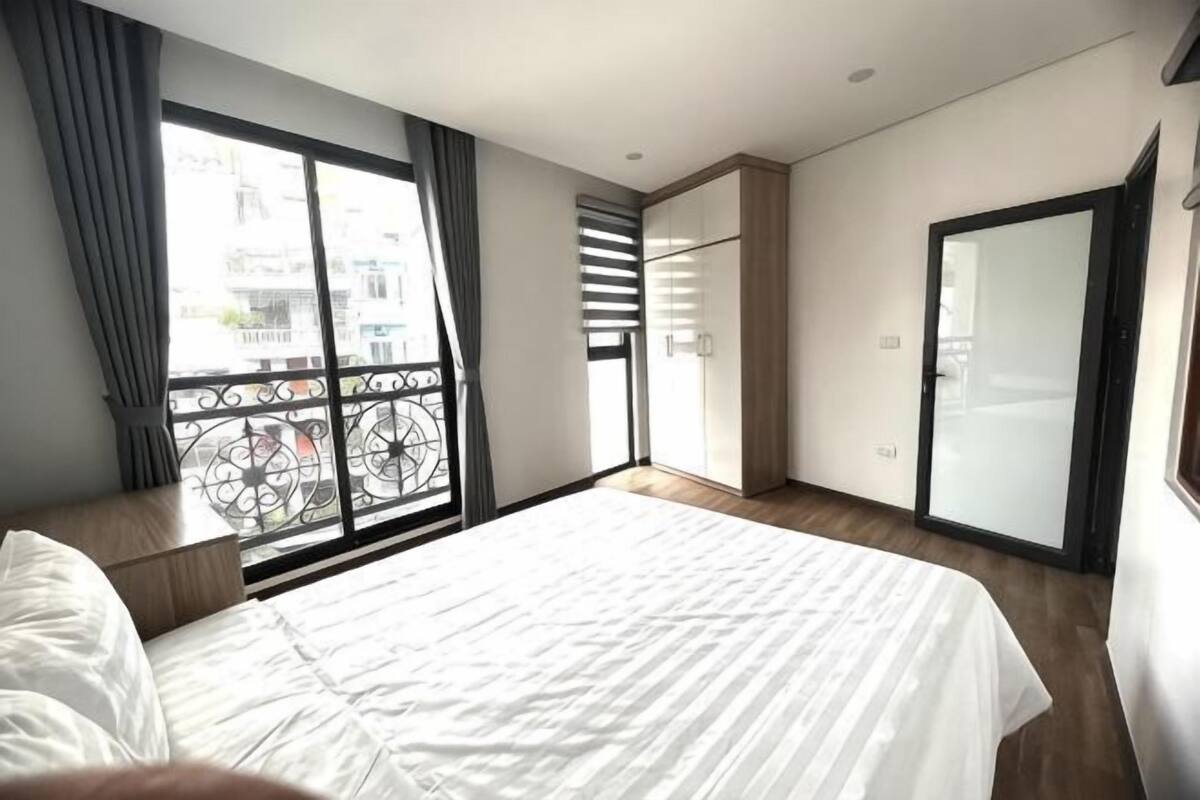 Quarto com uma cama grande, guarda-roupa, porta de correr e varanda com vista.