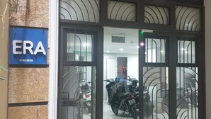 Entrada de um edifício com uma placa indicando 