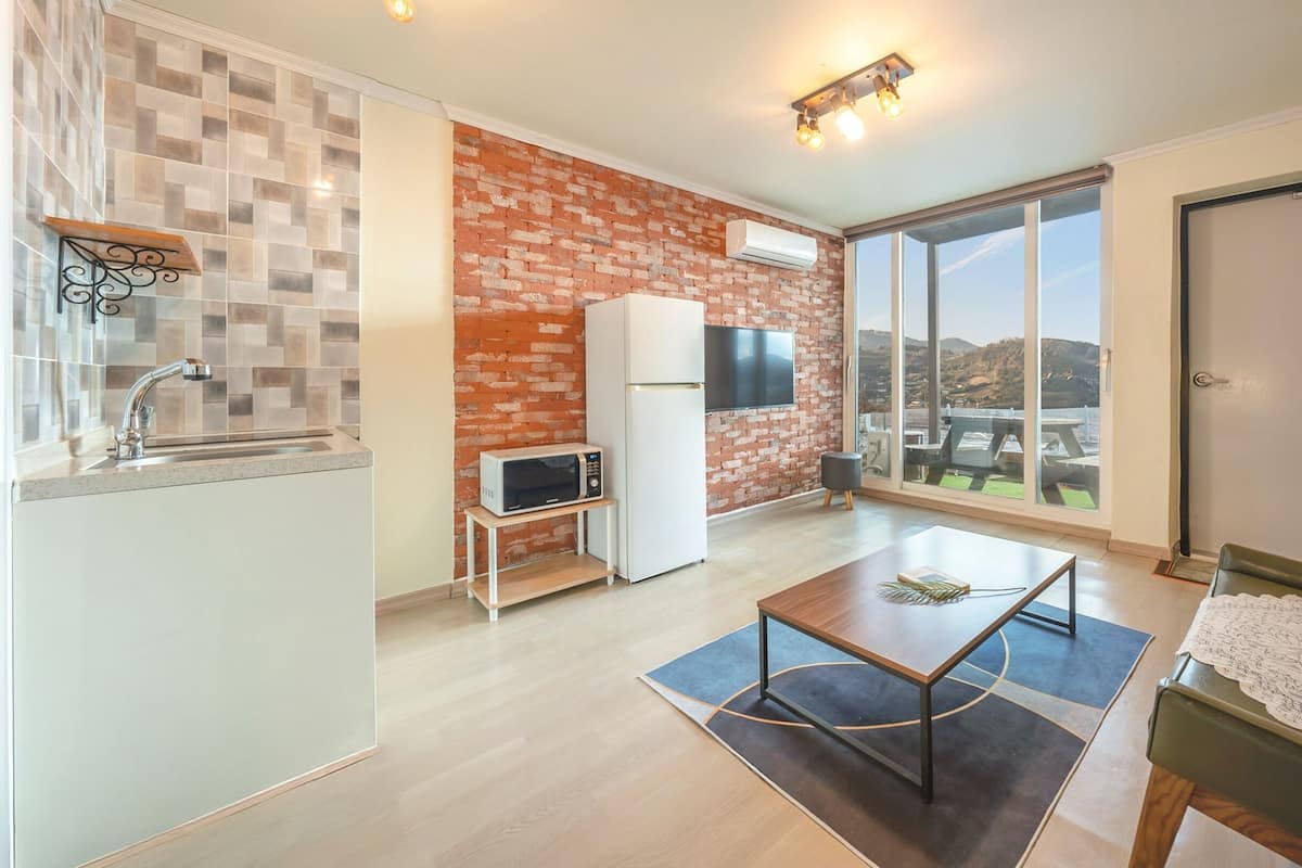 Um apartamento moderno com cozinha, sala de jantar e uma grande janela com vista panorâmica.